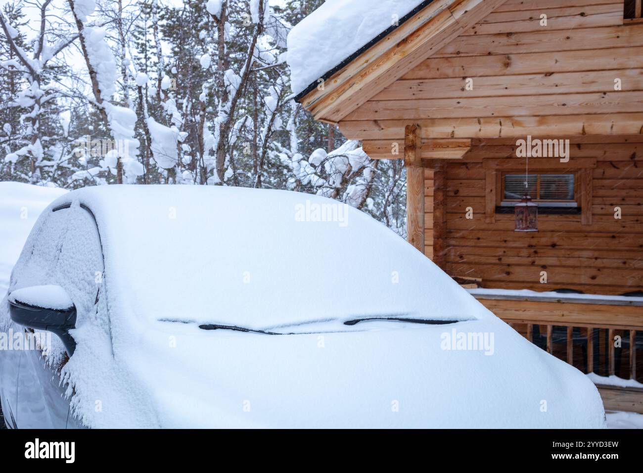 Finnish Lapland in winter. Snow-covered car in front of wooden cottage ...