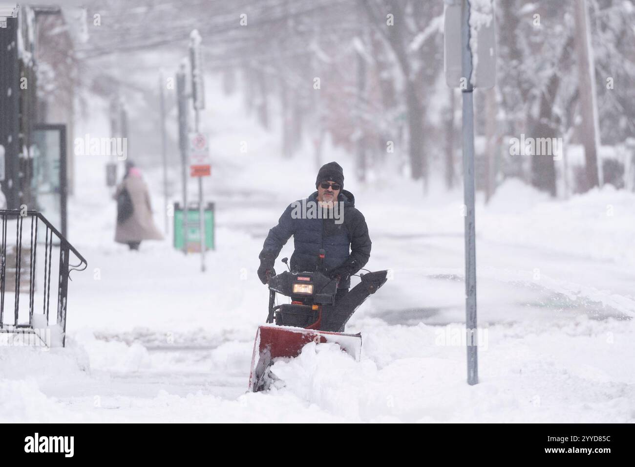A person clears snow with a snowblower following the first significant ...