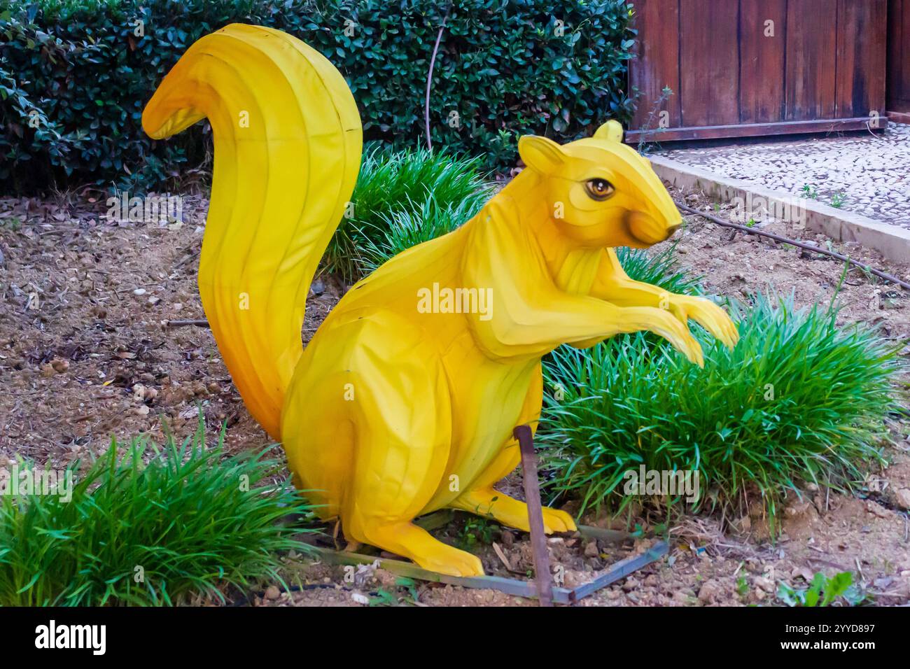 Bright Yellow Squirrel Sculpture in a Garden Setting Surrounded by ...