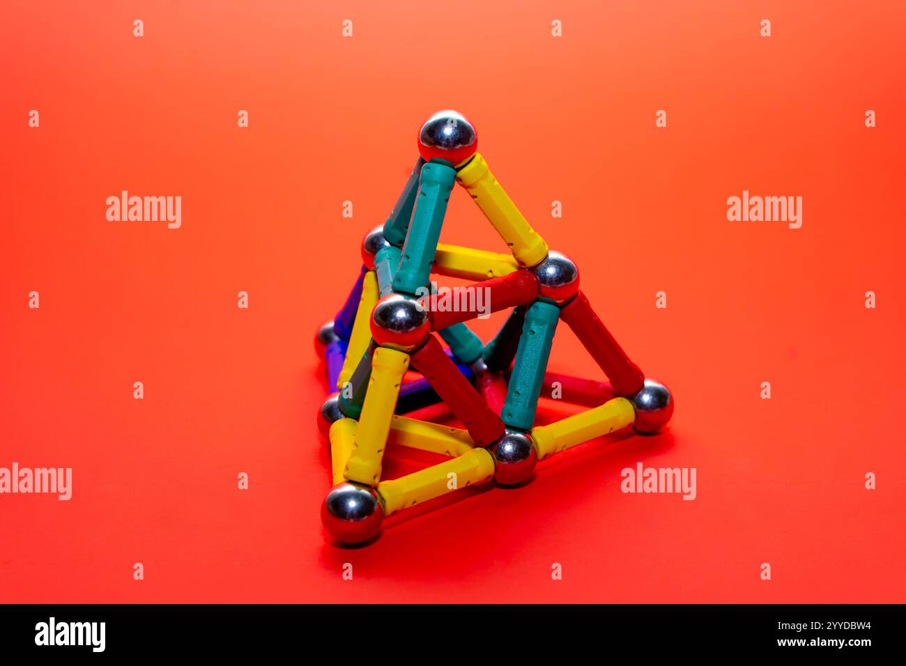 Brightly colored magnetic building pieces are assembled into a ...