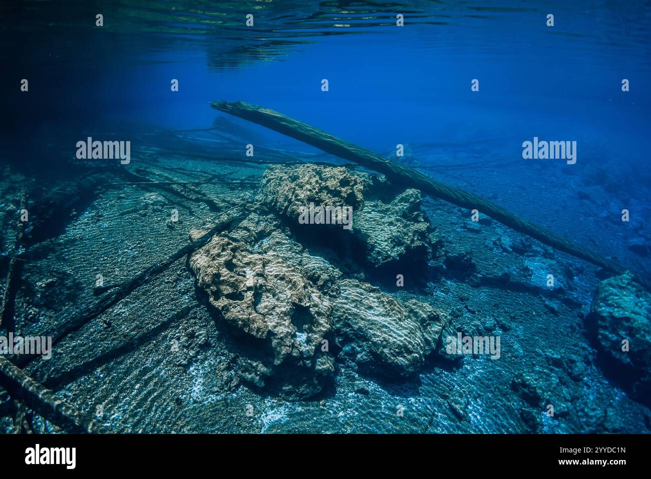 Sunken logs with rocks underwater in crystal blue lake Stock Photo - Alamy