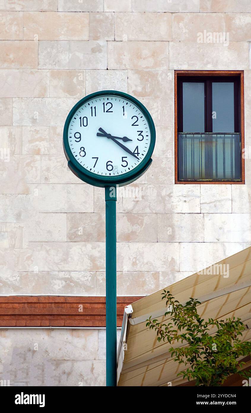 Simple style clock on city pole outside in street Stock Photo - Alamy