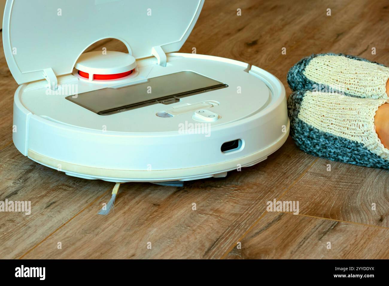 White robot vacuum cleaner. Female feet in socks. close-up. Home ...