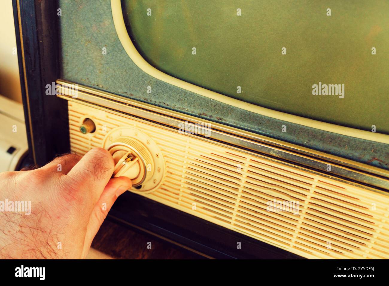 The hand changes channels on the retro old TV. Turning on of the ...