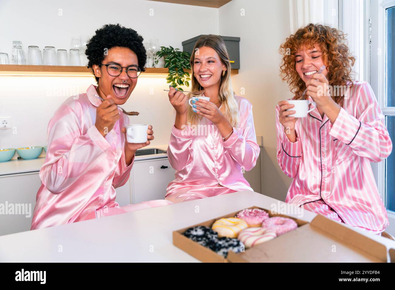 Multiethnic group of young female friends having pajamas party at home ...