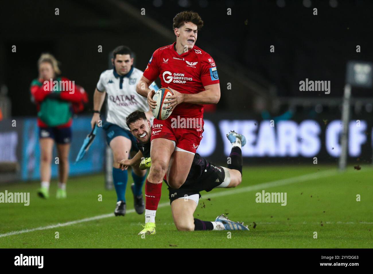 Swansea, UK. 21 December, 2024. Eddie James of Scarlets gets away from Owen Watkin of Ospreys ...