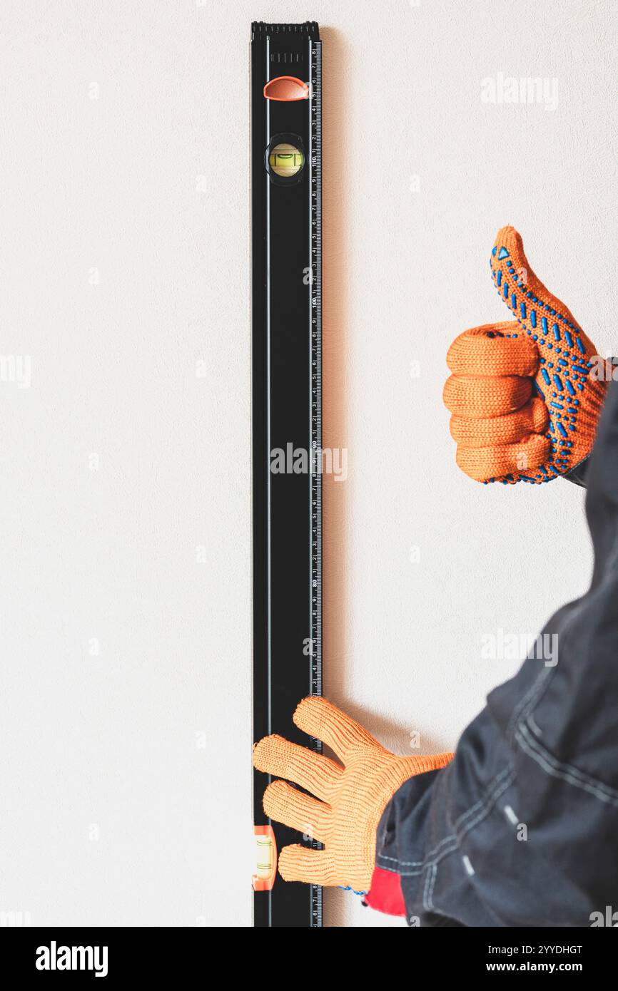 Worker's hands with bubble level. measuring with bubble level ...
