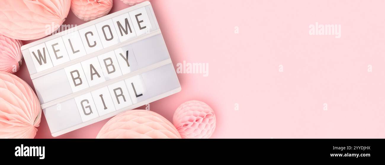 Welcome baby girl. Banner with lightbox and tissue paper balls in a ...