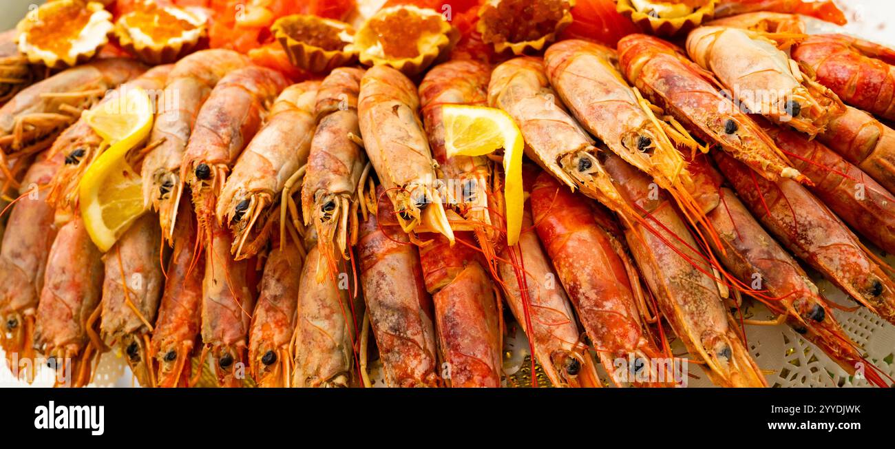 A colorful seafood platter displays an array of large, cooked shrimp ...
