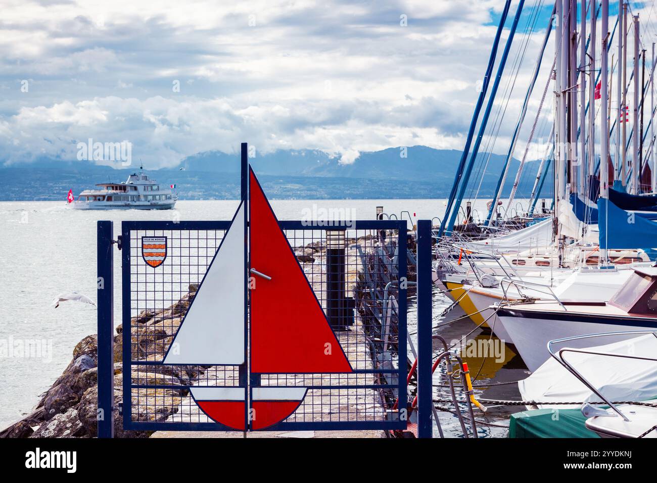 Ferry sailing on waters of Lake Geneva and boats docked at the Port of ...