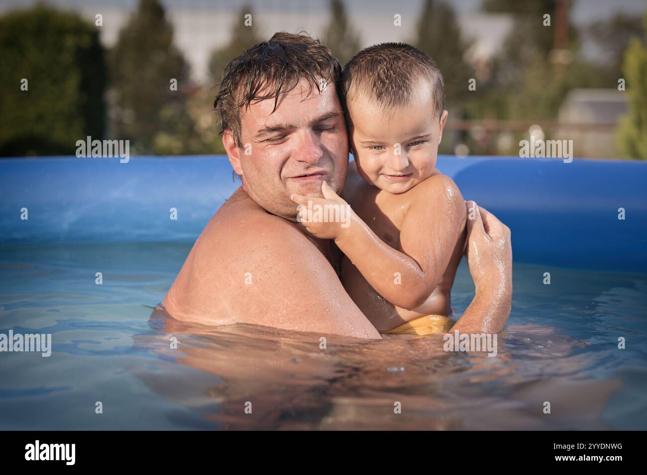 Couple of man and baby cooling during hot day in swimming pool on ...