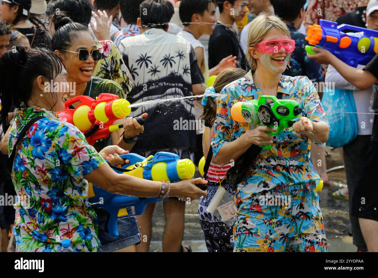 Bangkok, Thailand - April 13, 2023: Revelers splash water in each other using water guns during ...