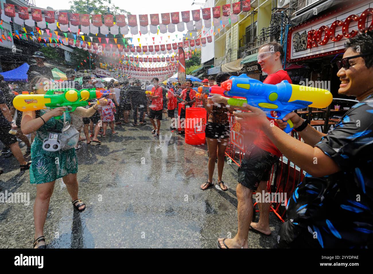 Bangkok, Thailand - April 13, 2023: Revelers splash water in each other using water guns during ...