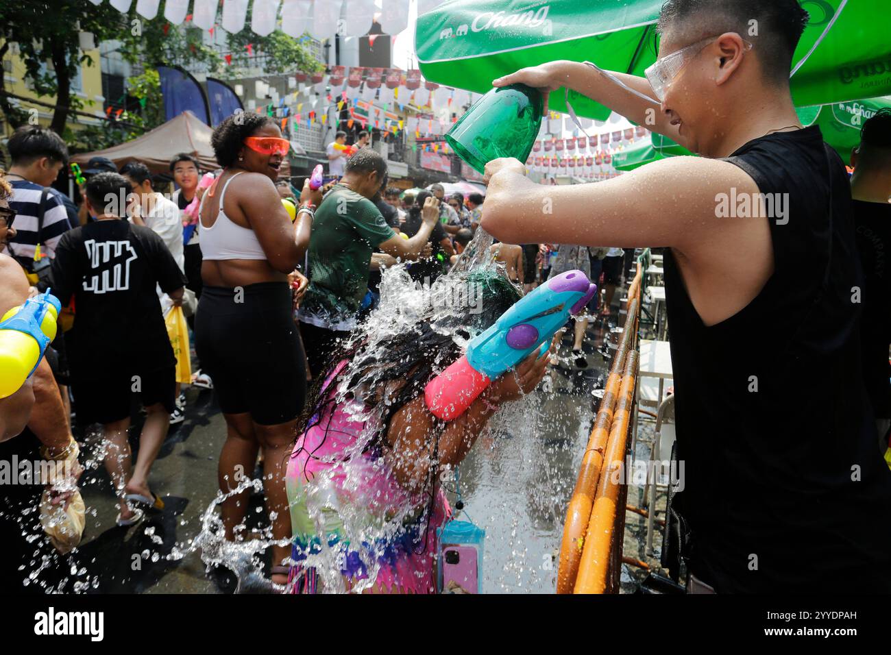 Bangkok, Thailand - April 13, 2023: Revelers splash water in each other using water guns during ...