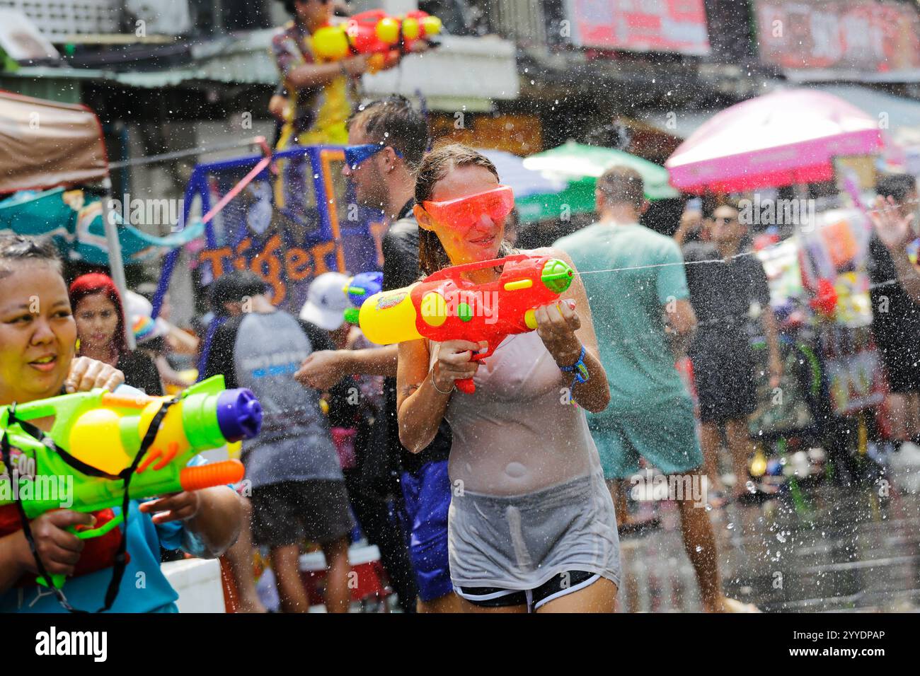 Bangkok, Thailand - April 13, 2023: Revelers splash water in each other using water guns during ...