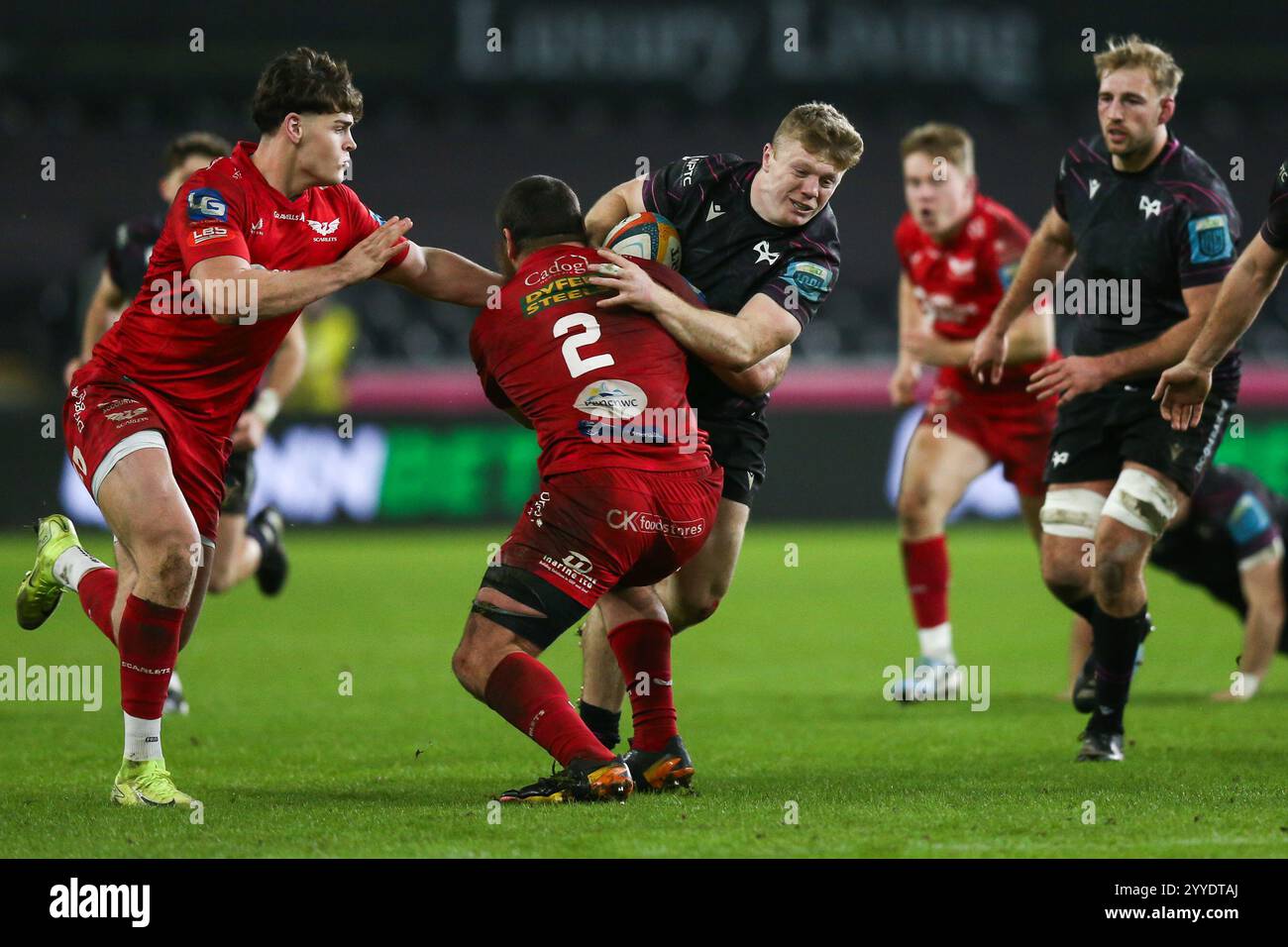 Swansea, UK. 21 December, 2024. Keiran Williams of Ospreys is tackled ...
