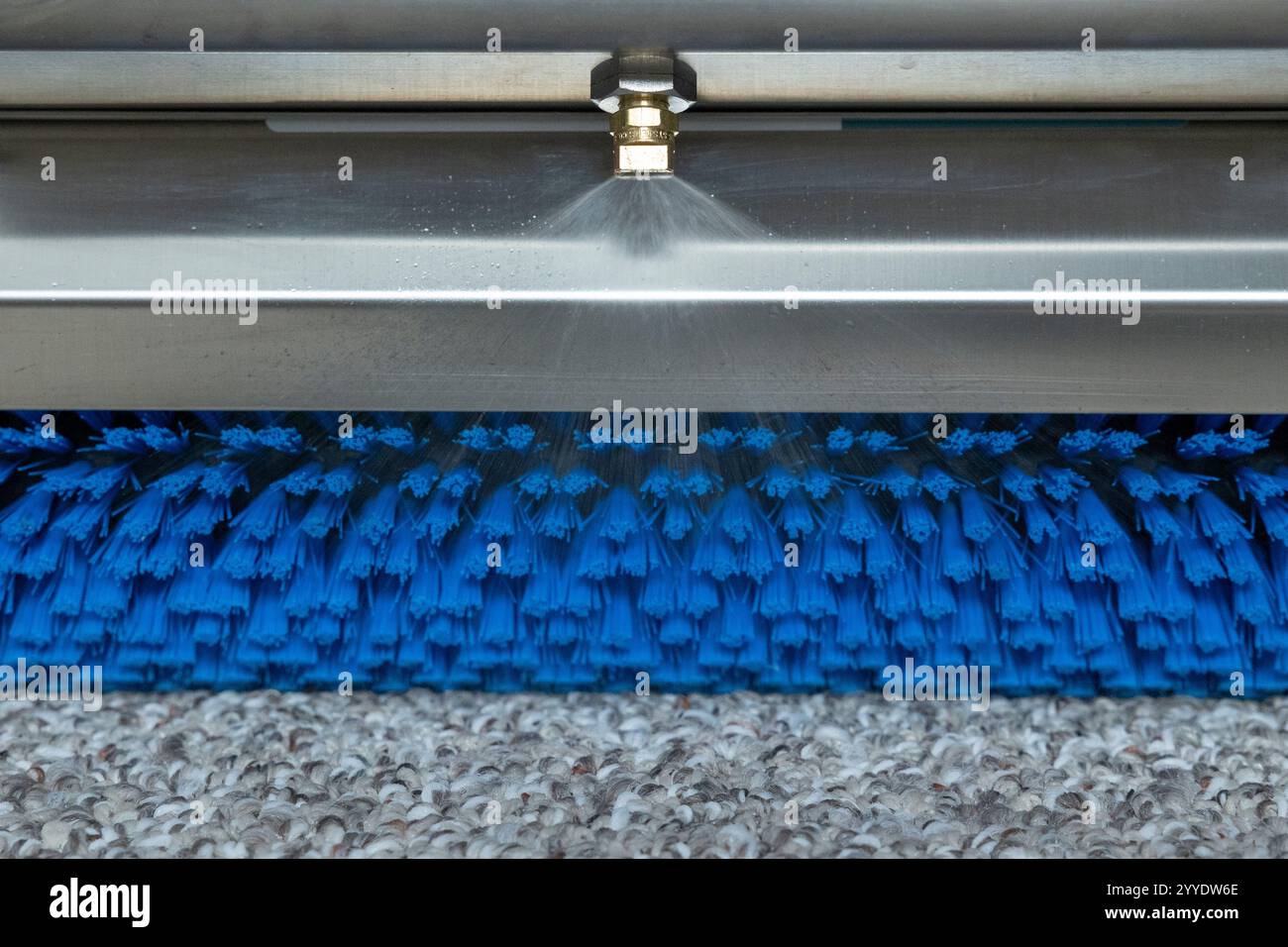 Spray jet applying cleaner and cylindrical blue brush of a counter ...