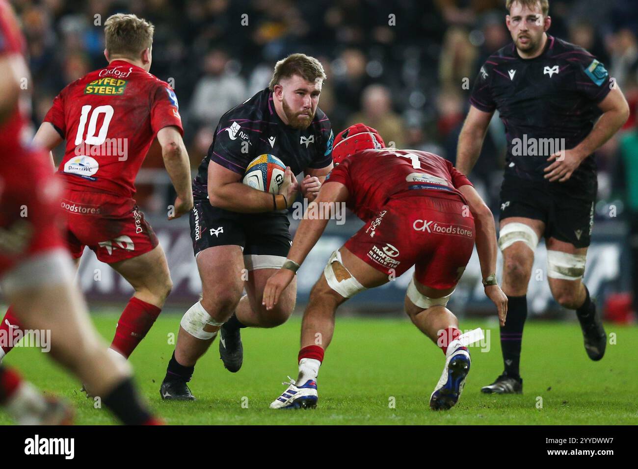 Swansea, UK. 21 December, 2024. Garyn Phillips of Ospreys takes on Josh ...