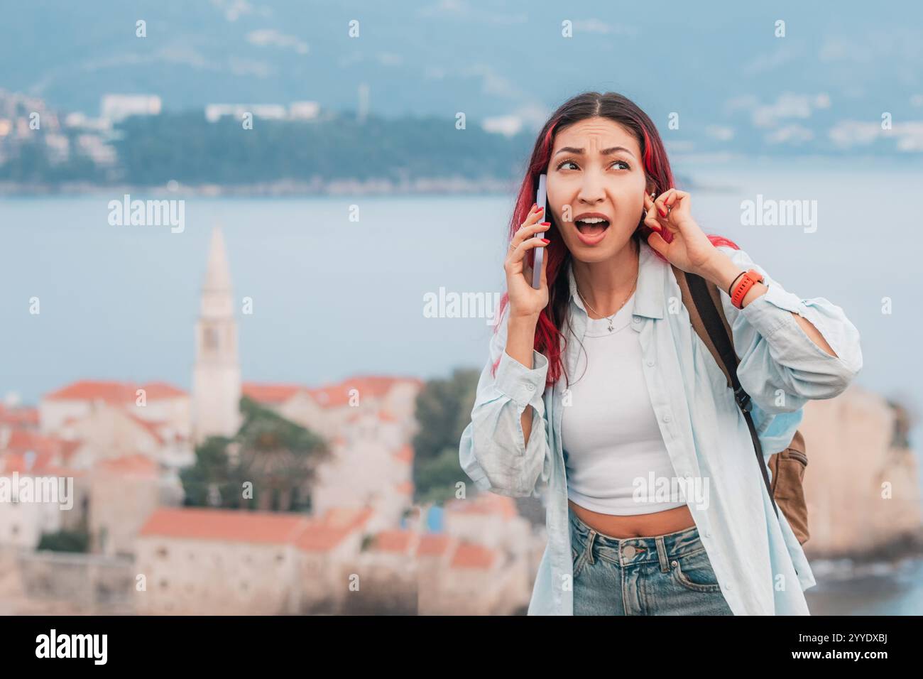 A woman struggles with poor phone reception while talking in front of ...