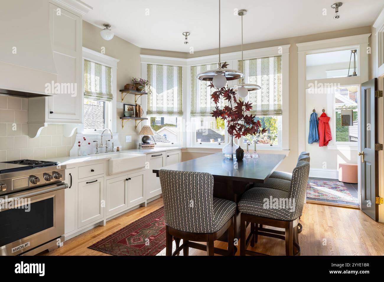 Summy kitchen with striped window shades and view into mudroom Stock ...