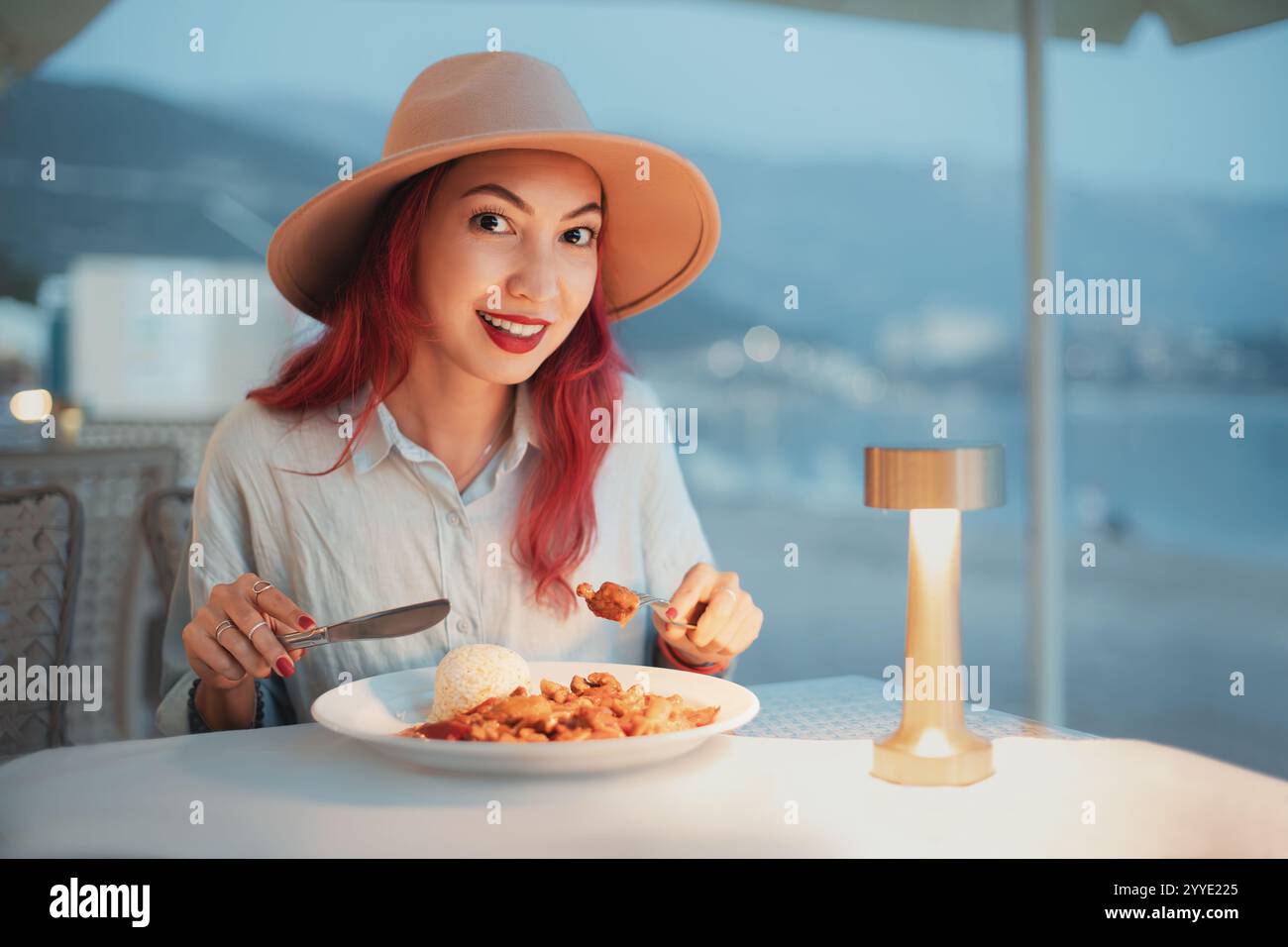 Tourist woman eating dinner in outdoor restaurant by the sea Stock ...