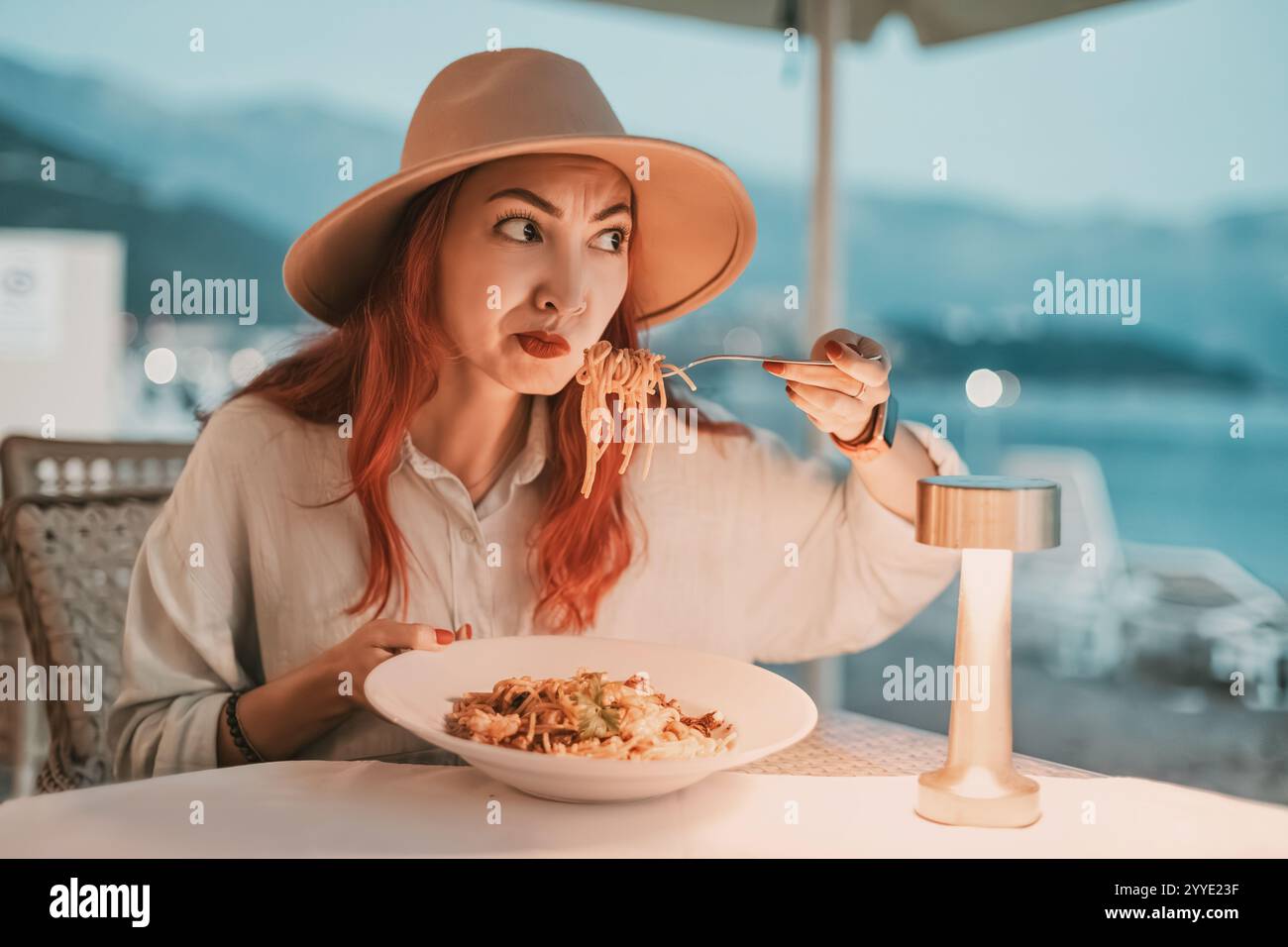 Tourist having dinner in a restaurant with sea view, looking disgusted ...