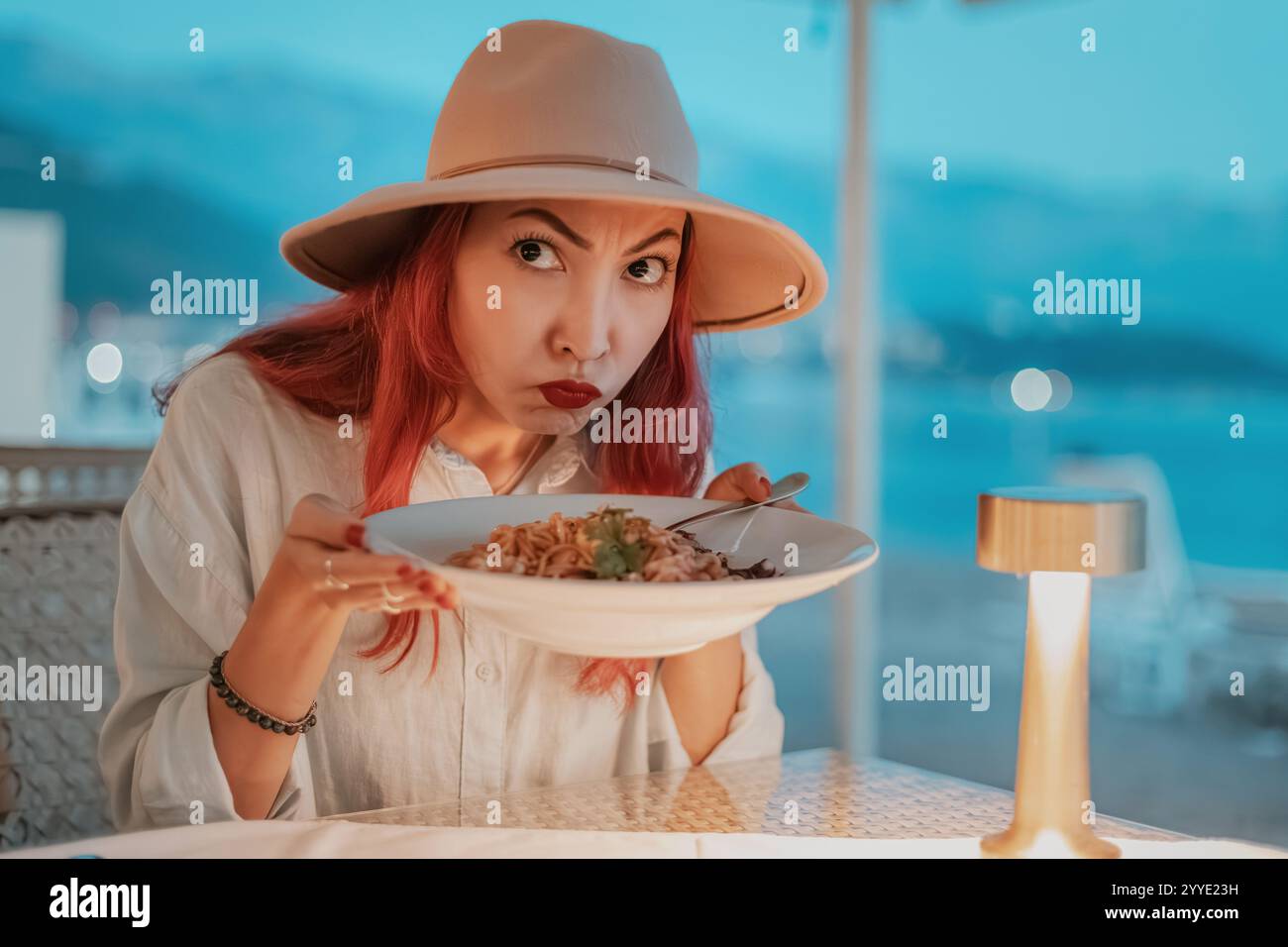 Tourist having dinner in a restaurant with sea view, looking disgusted ...