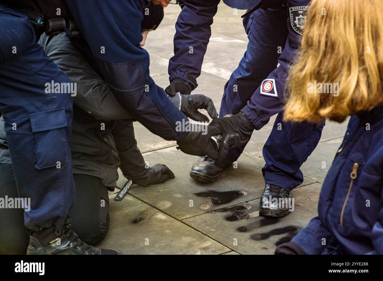 Police officers wrestles a spray paint can from the hands of a ...