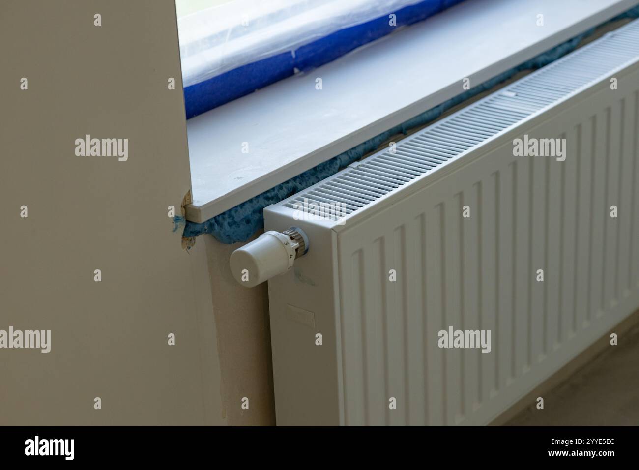 White home heating radiator with adjustable thermostat installed ...