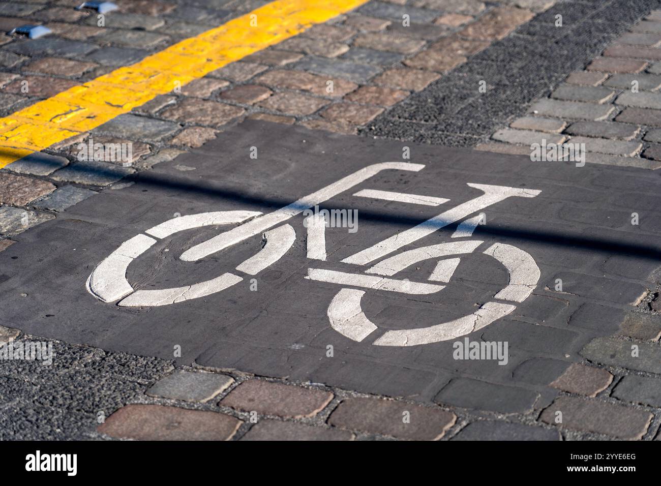 Bike Lane Symbol on Cobblestone Street with Yellow Divider Line Stock ...
