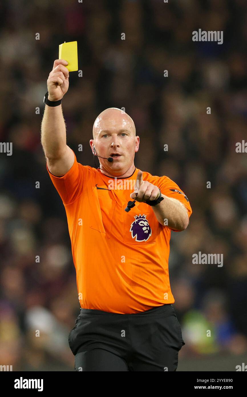 Match referee Simon Hooper issues a yellow card during the Premier ...