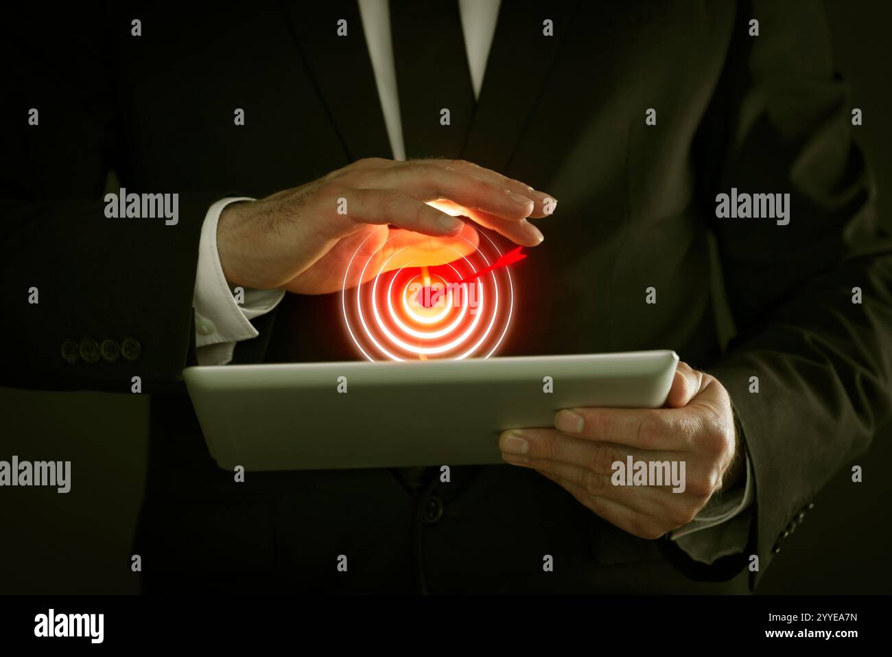 Businessman holding tablet and virtual target with arrow on dark ...