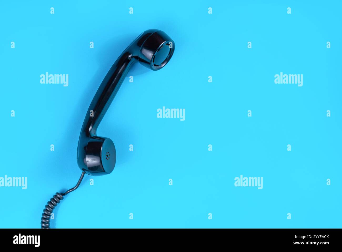 Old retro telephone handset on a classic blue background in a studio ...