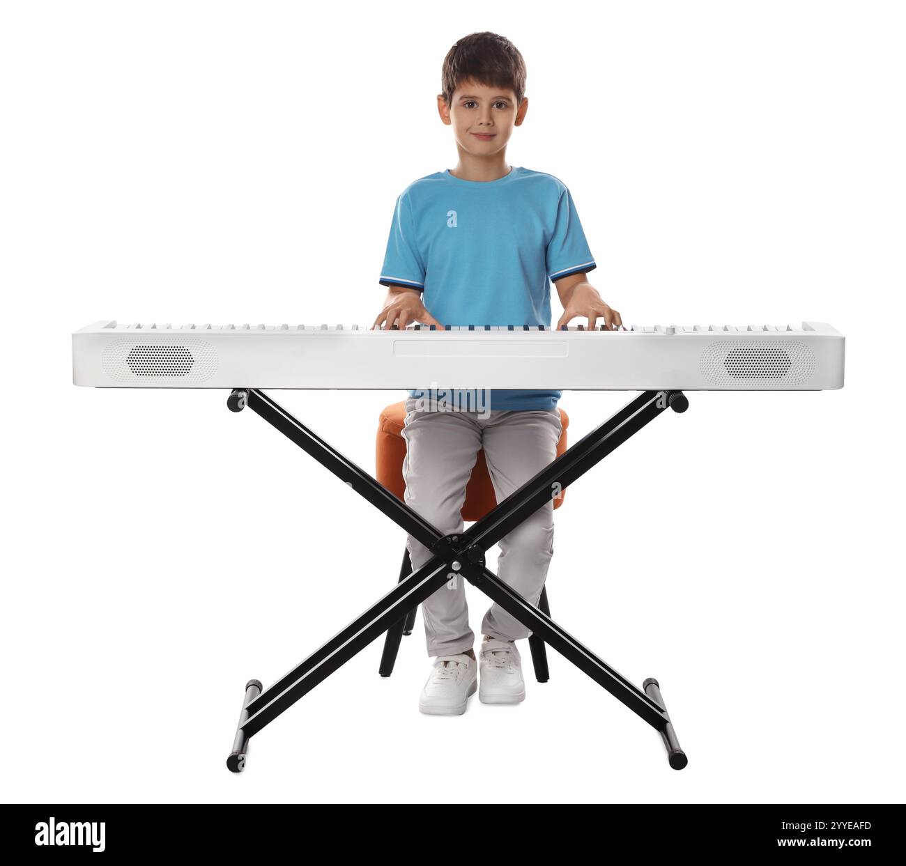 Cute boy playing synthesizer on white background Stock Photo - Alamy