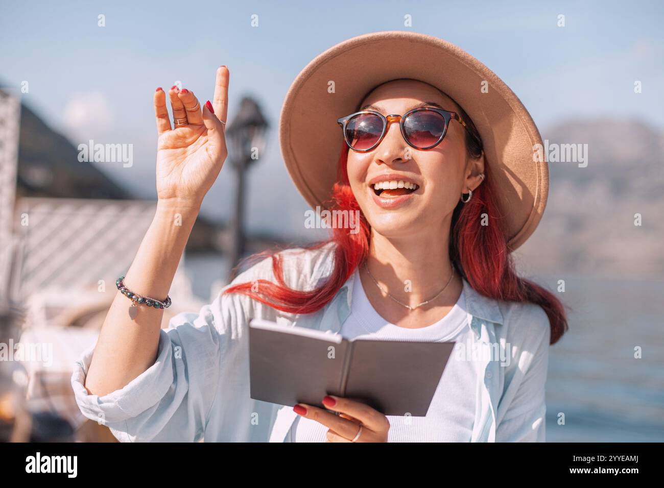 Tourist smiling and reading menu in outdoor restaurant by the sea and ...