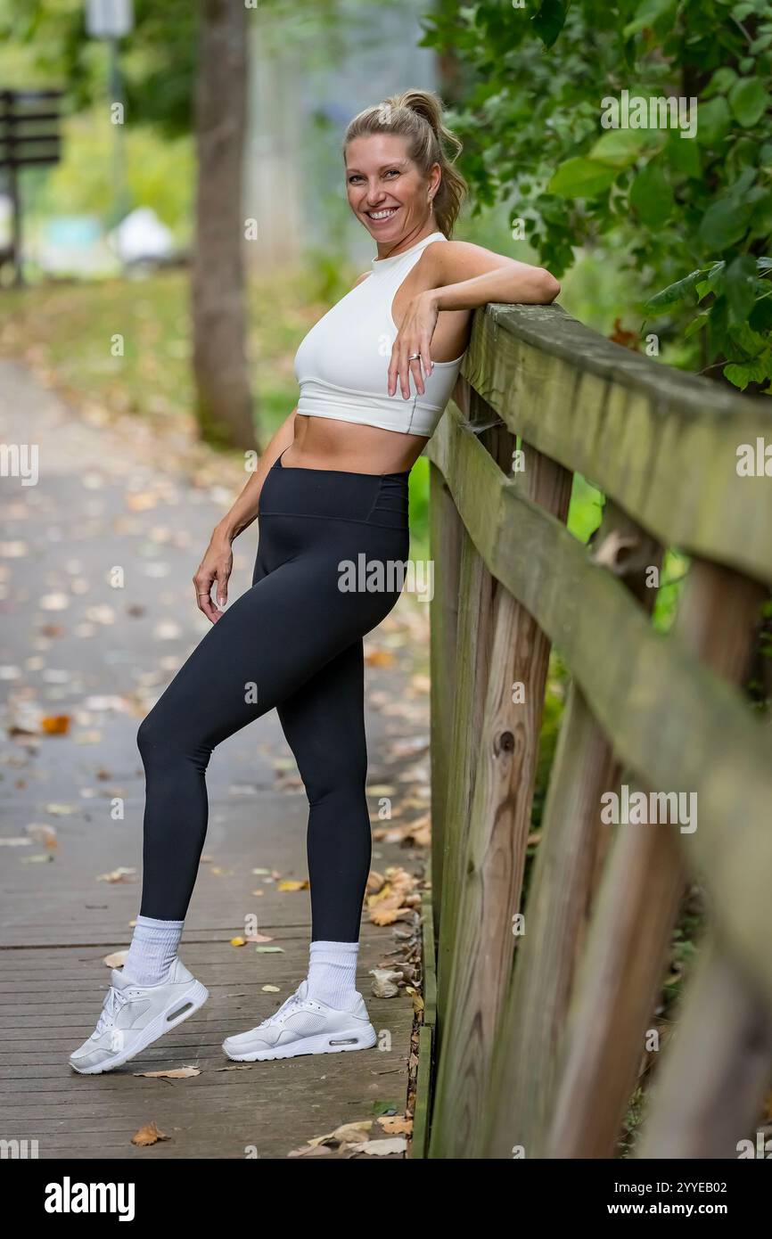 A gorgeous blonde model, dressed in sleek workout clothes, takes a well ...