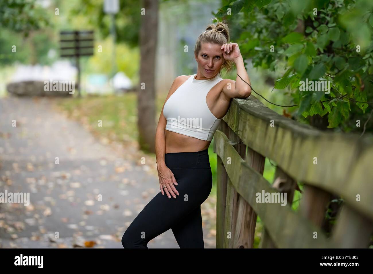 A gorgeous blonde model, dressed in sleek workout clothes, takes a well ...