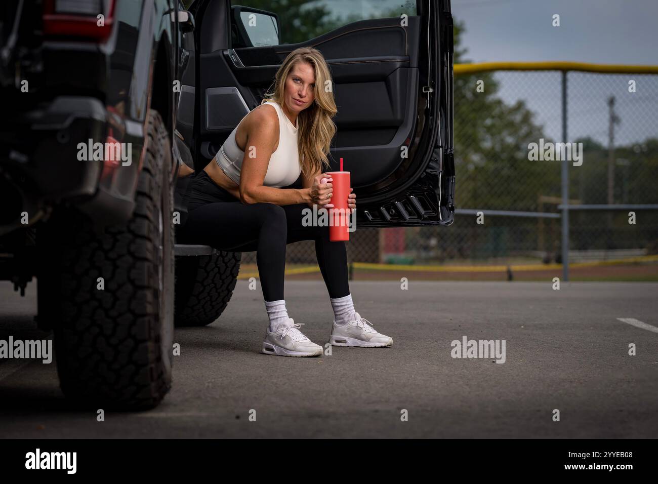 A gorgeous blonde model, dressed in sleek workout clothes, takes a well ...