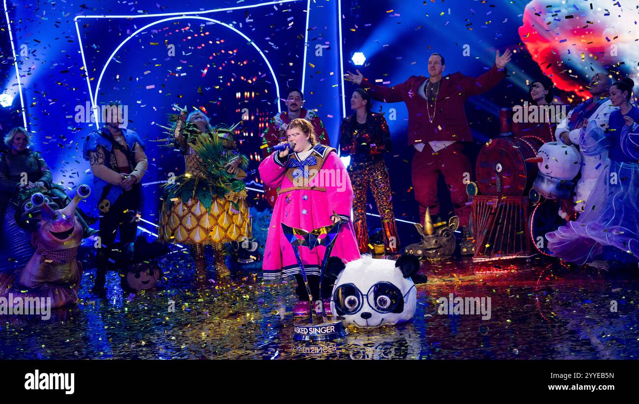 Cologne, Germany. 21st Dec, 2024. Singer Loi stands next to the trophy ...