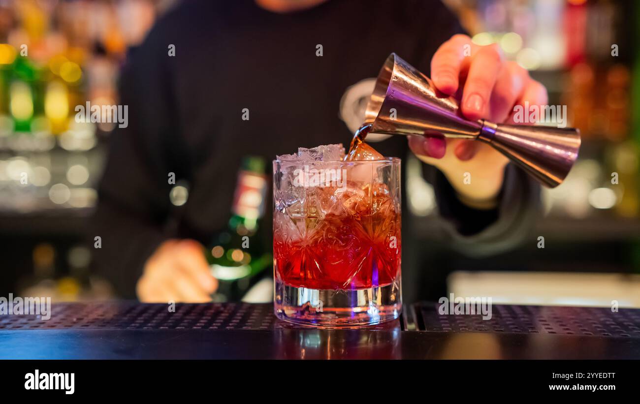 The bartender pours a red cocktail Stock Photo - Alamy