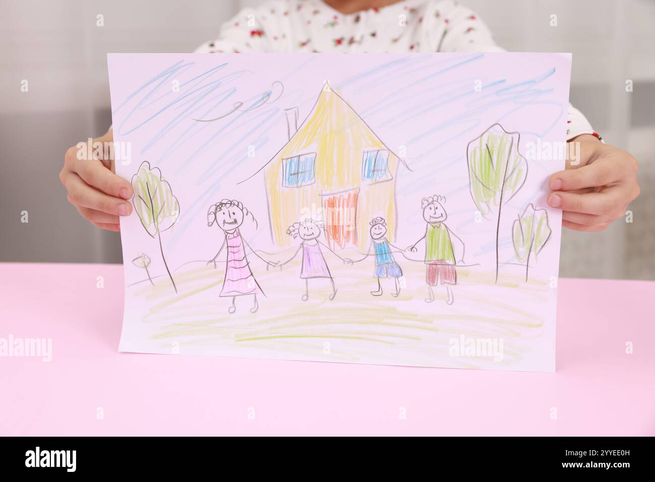 Adoption. Little girl holding drawing of family at pink table, closeup ...