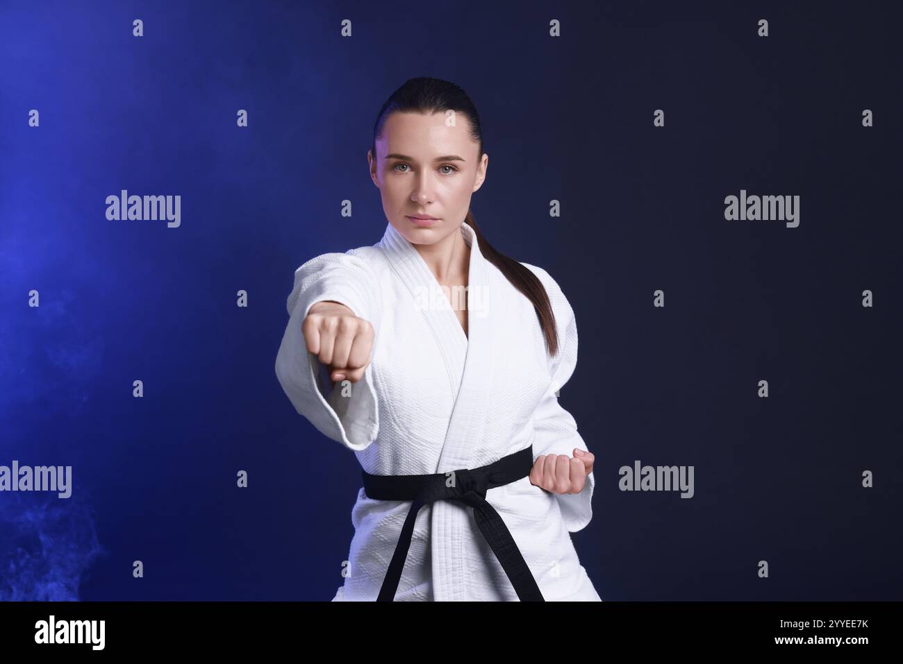 Karate fighter in kimono on dark blue background Stock Photo - Alamy