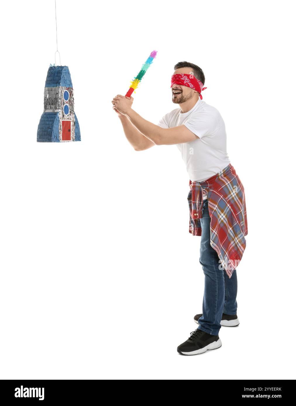 Blindfolded man hitting rocket shaped pinata with stick on white ...