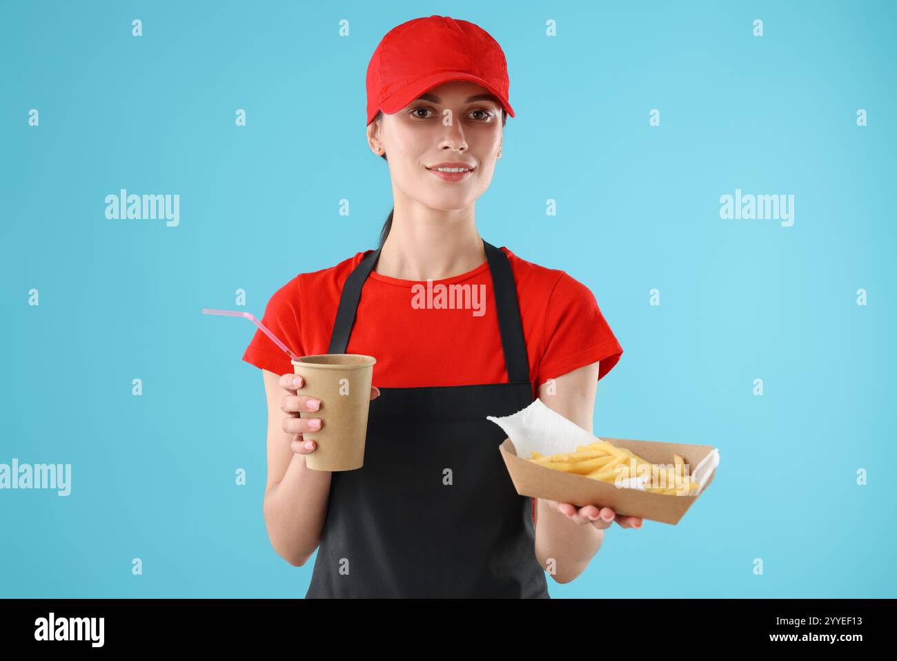 Fast-food worker with paper cup and fries on light blue background ...