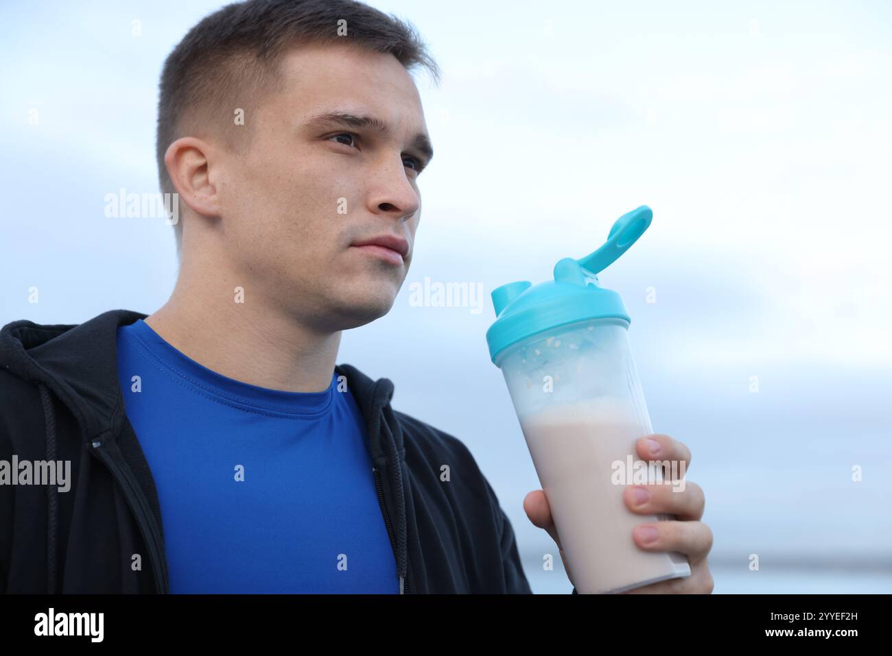 Athletic man with shaker of protein drink outdoors Stock Photo - Alamy