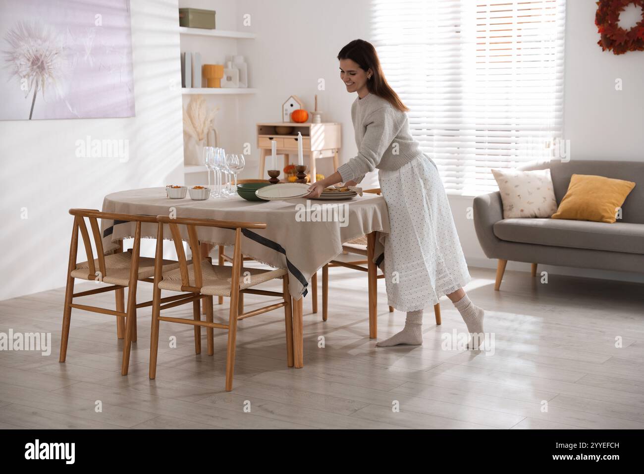 Woman setting table for dinner at home Stock Photo - Alamy