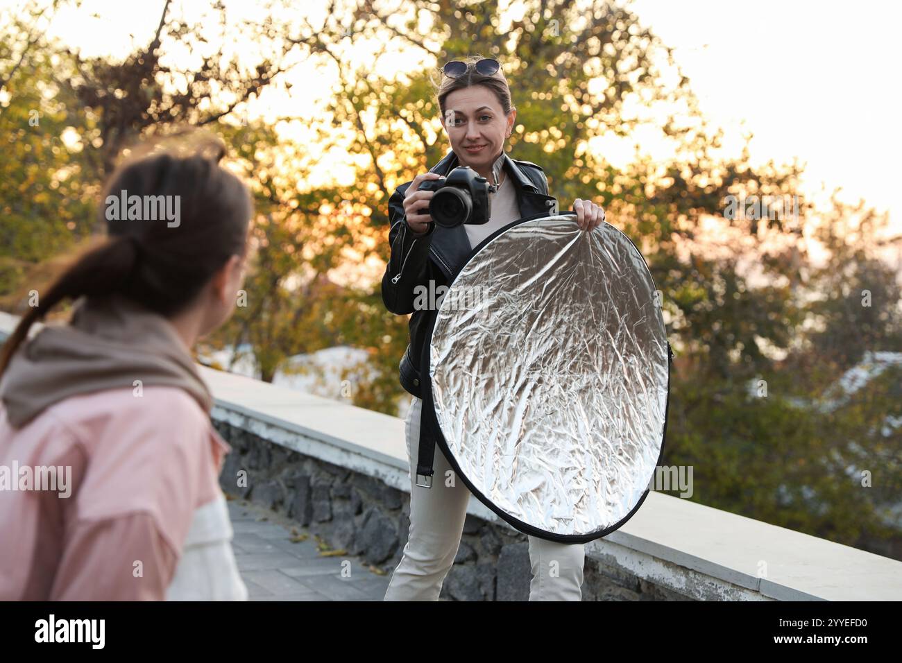 Professional photographers with reflector and camera outdoors Stock ...