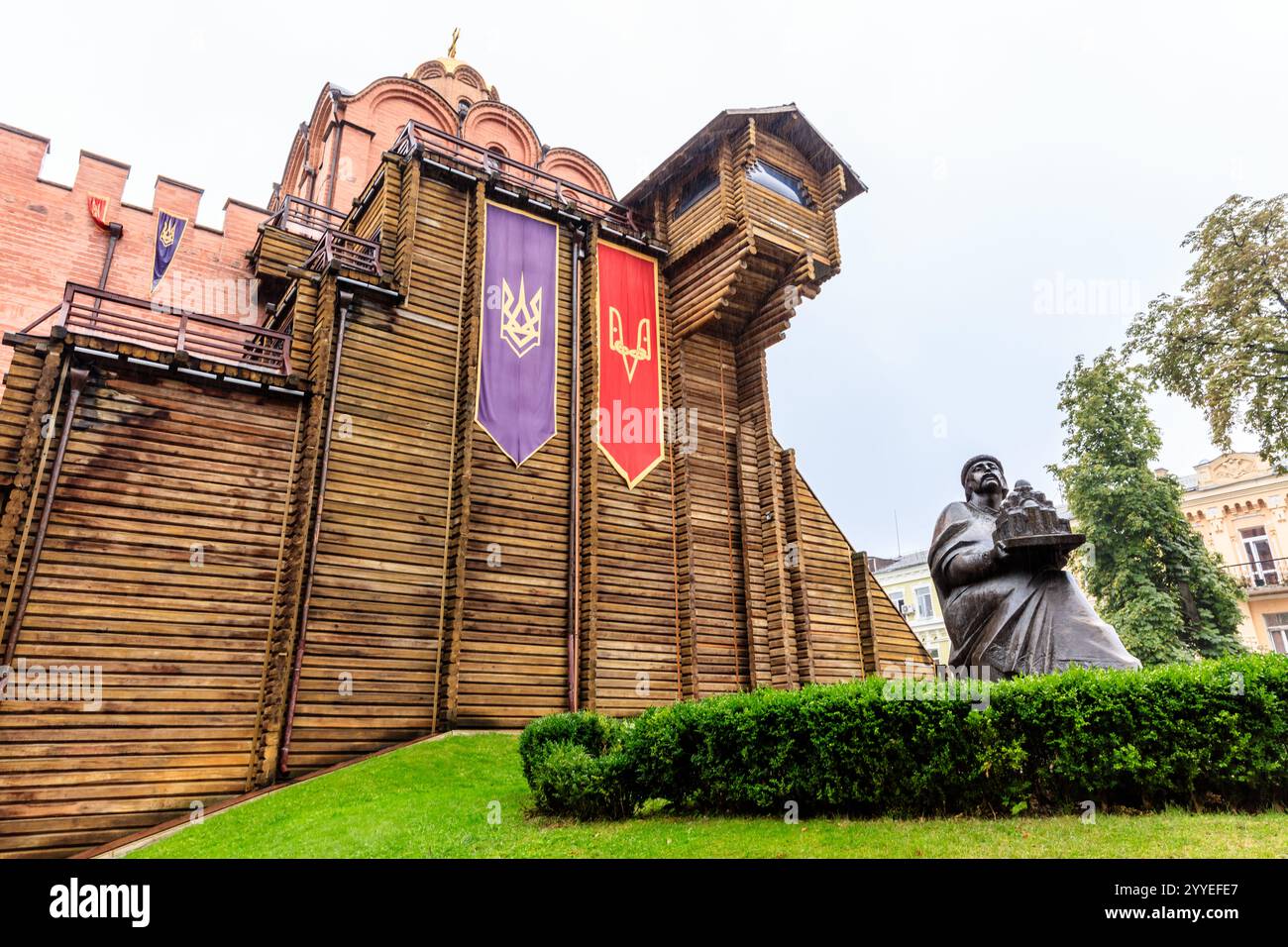 A large wooden building with a statue of a man sitting on a bench in ...