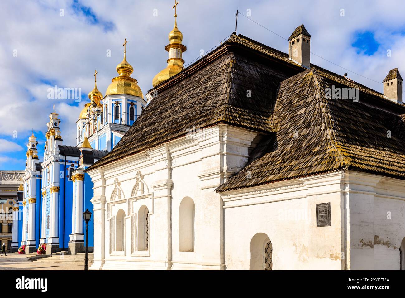 A white building with a blue roof and gold trim. The building is ...