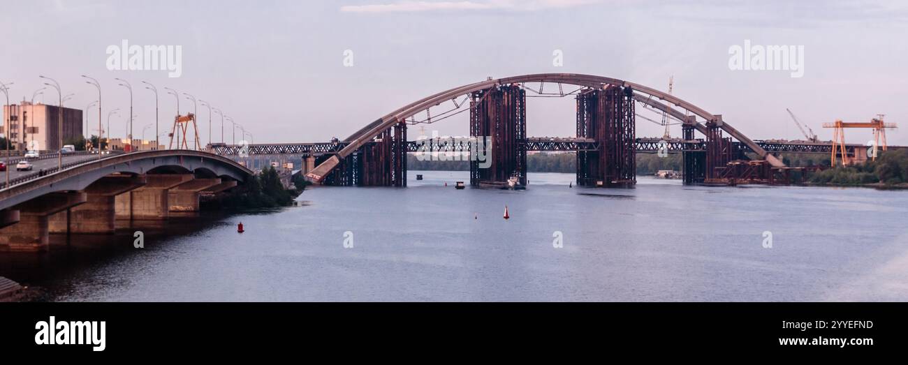 A bridge is being built over a river. The bridge is large and spans ...
